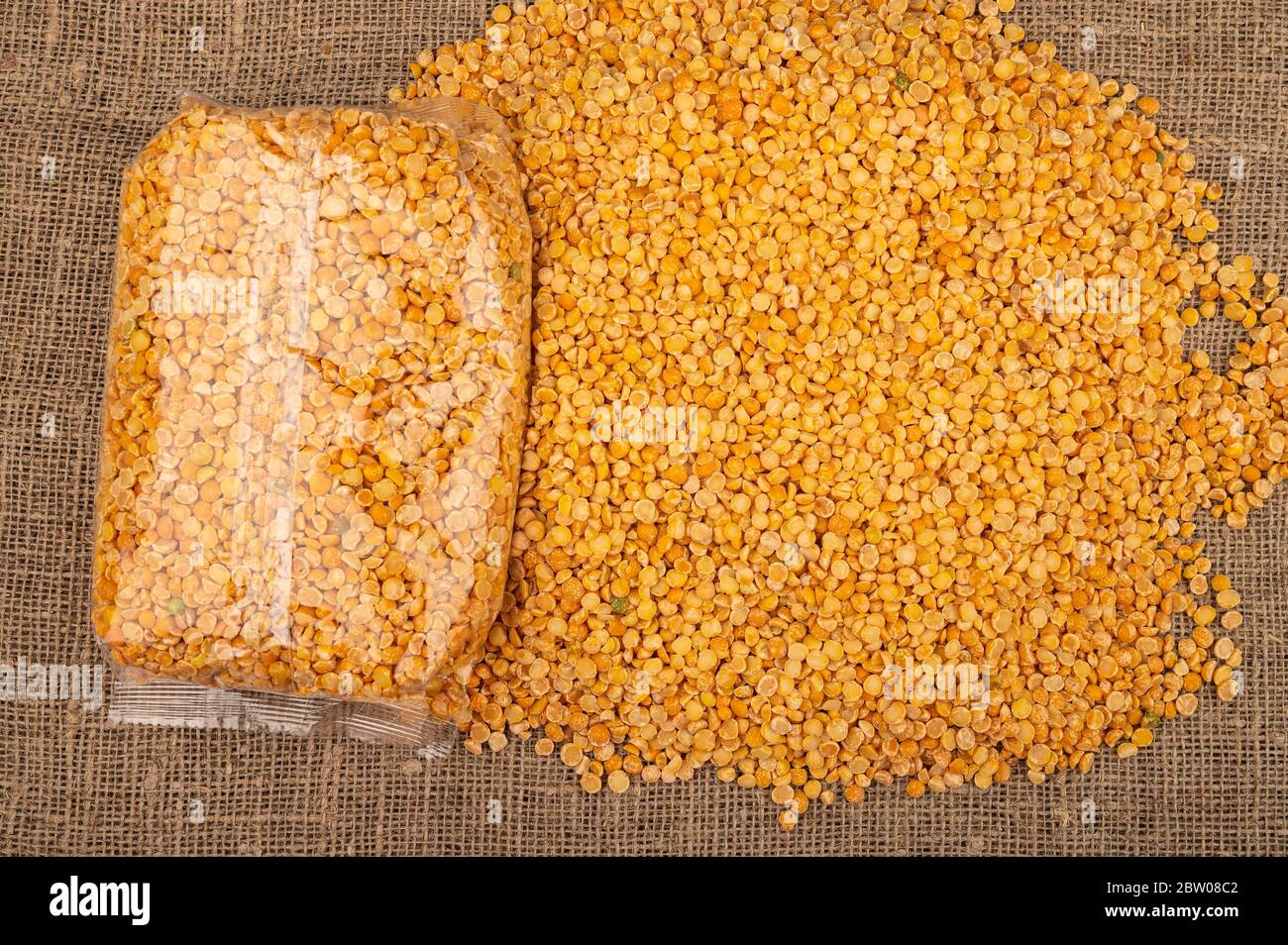 Yellow split peas in a plastic bag and cereal in bulk on a background ...