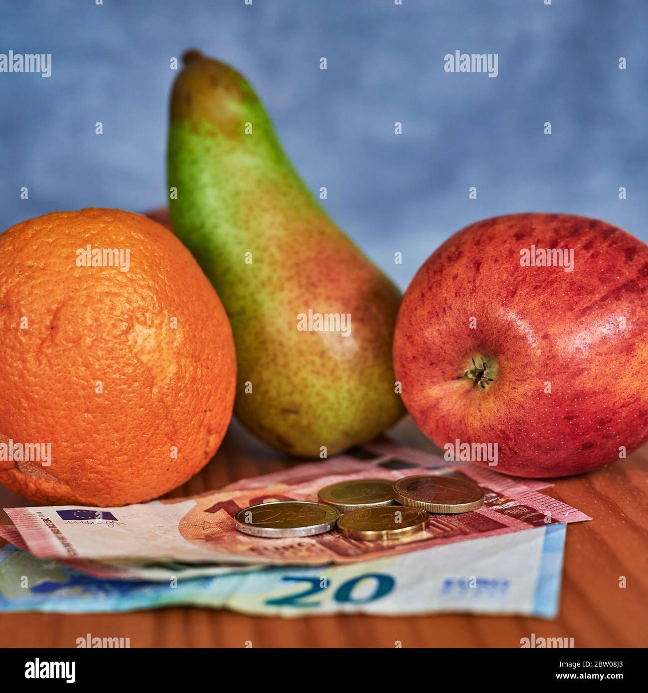 Fruit lying together with European banknotes and coins on a wooden ...