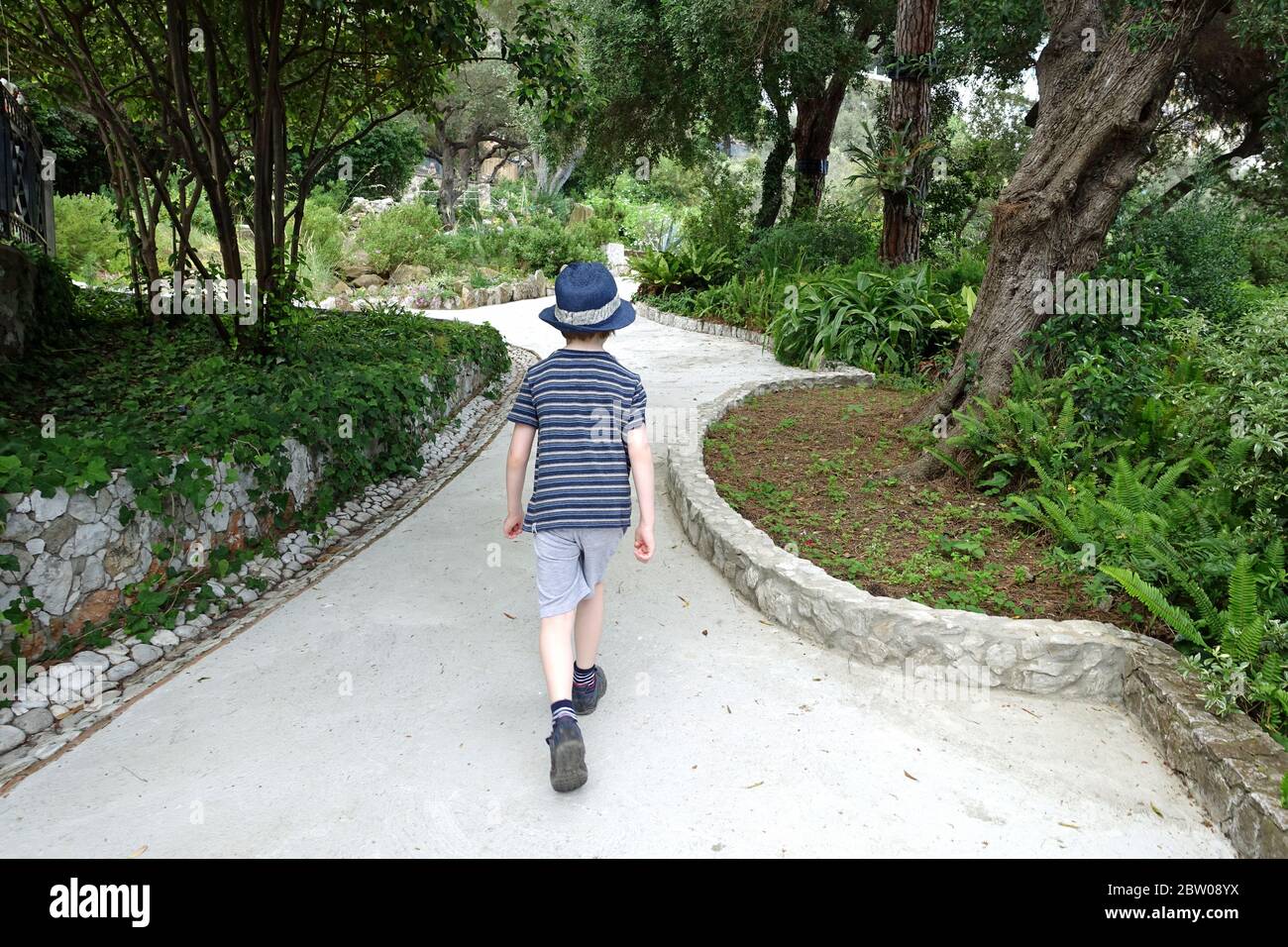 Boy walking along sidewalk hi-res stock photography and images - Alamy