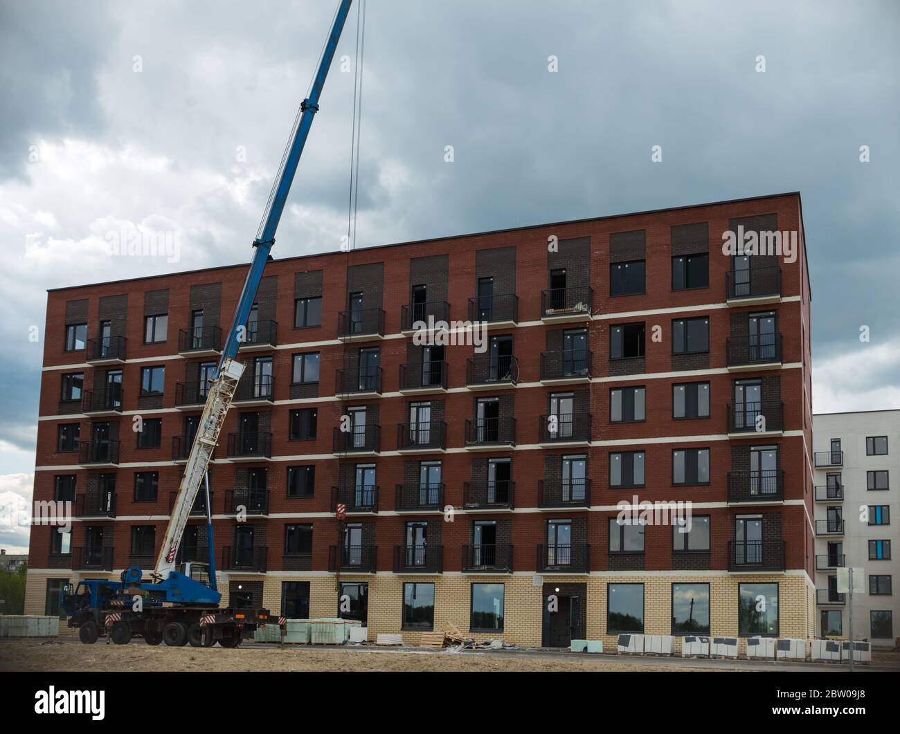 Mobile crane is lifting heavy material at construction site ...