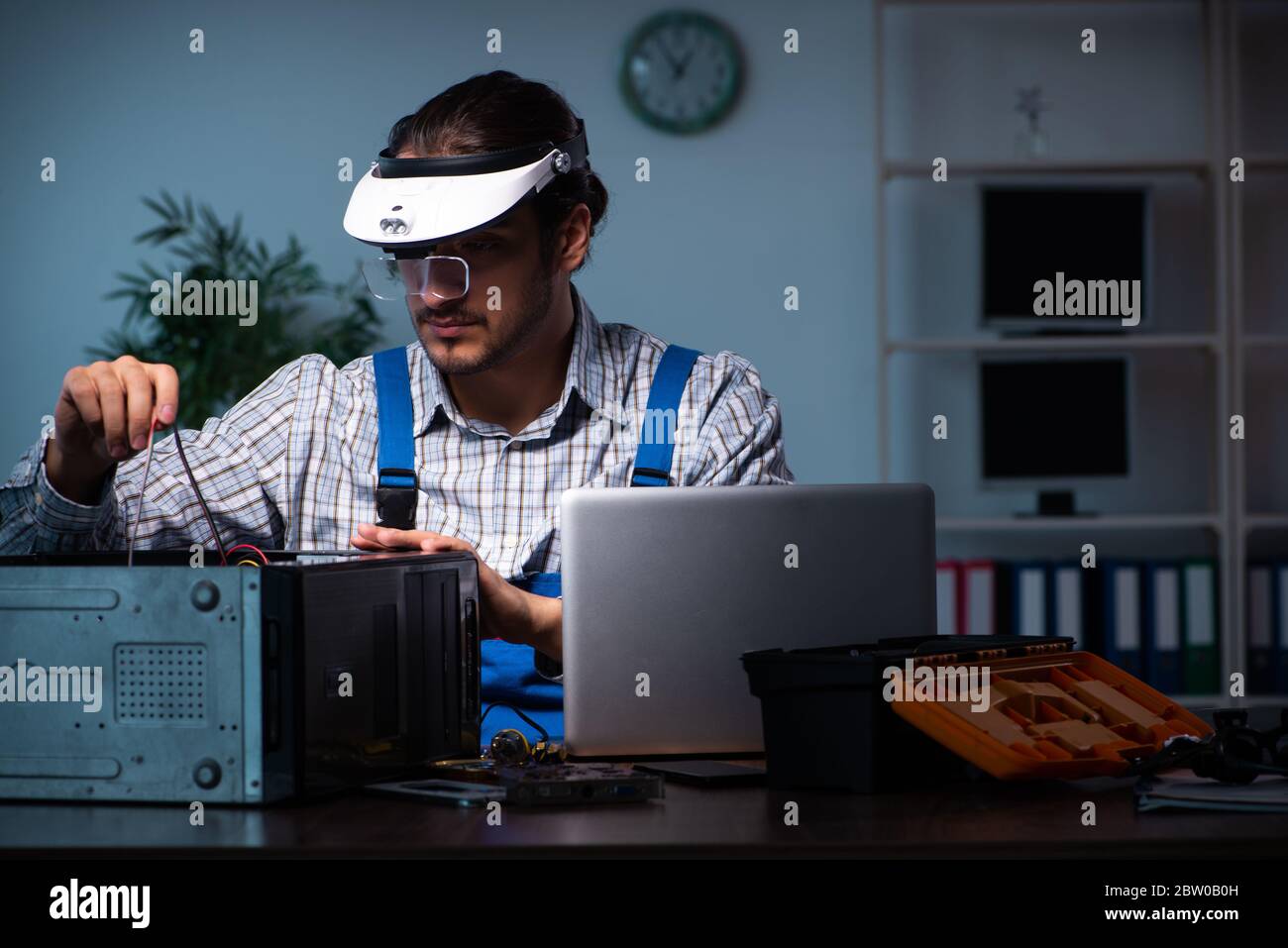 Young technician repairing computer in workshop at night Stock Photo ...