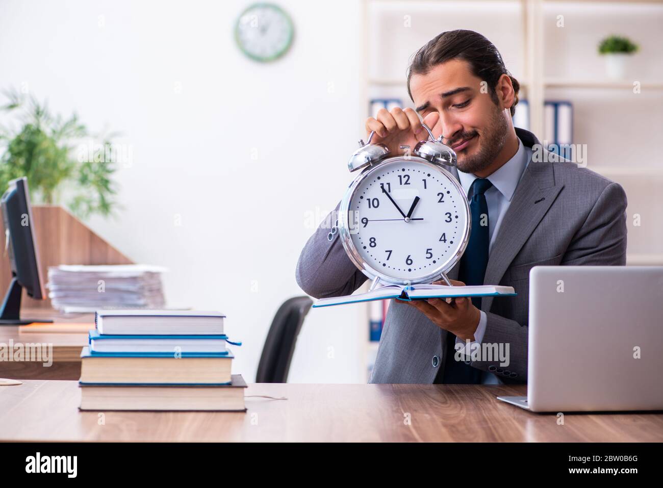 Young businessman reading books at workplace Stock Photo - Alamy