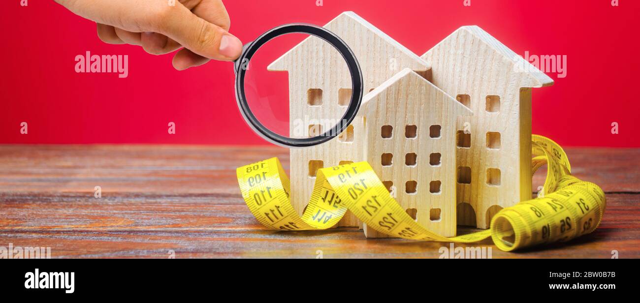 Miniature wooden houses and measuring tape. Home appraisal and property ...