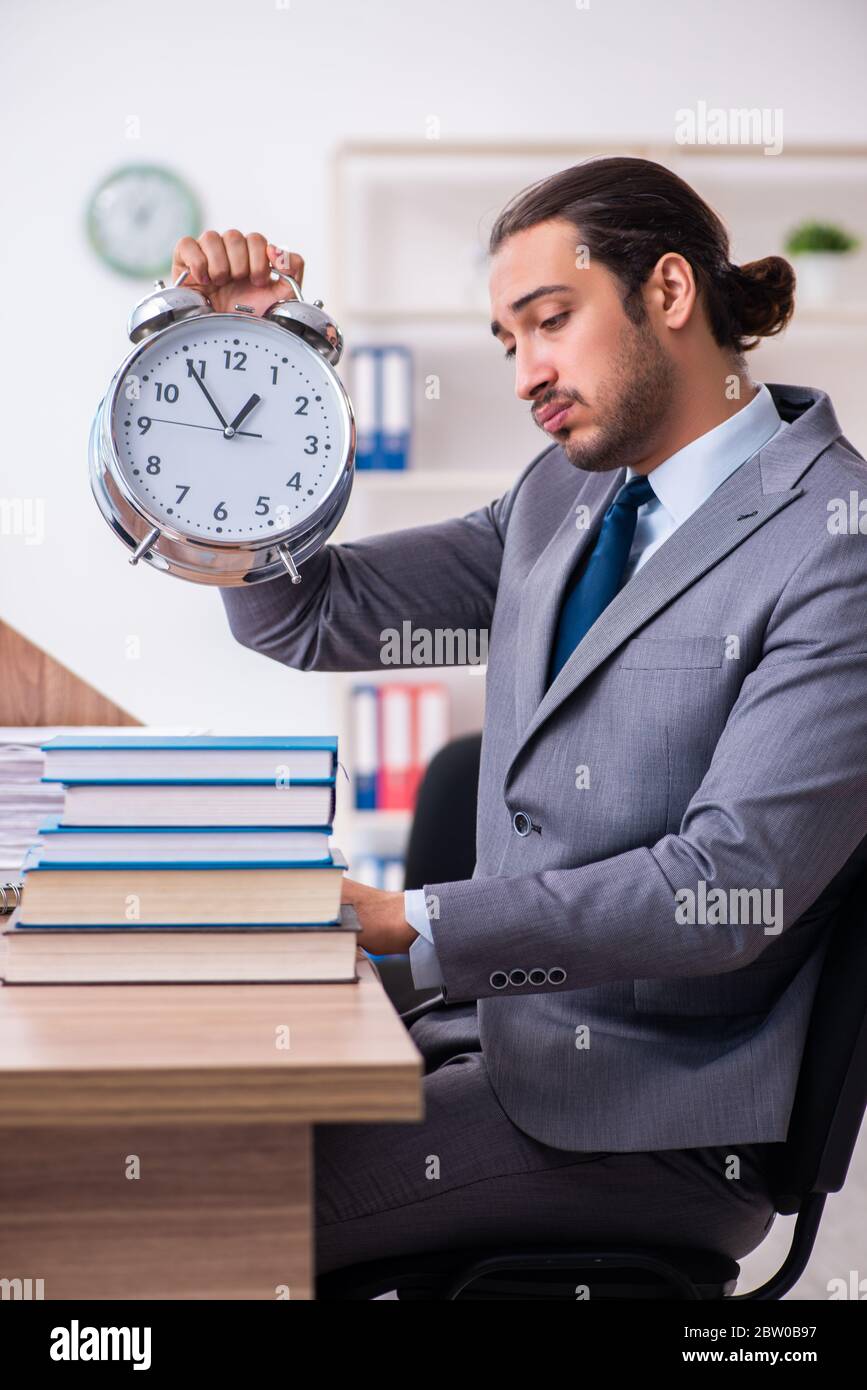 Young businessman reading books at workplace Stock Photo - Alamy
