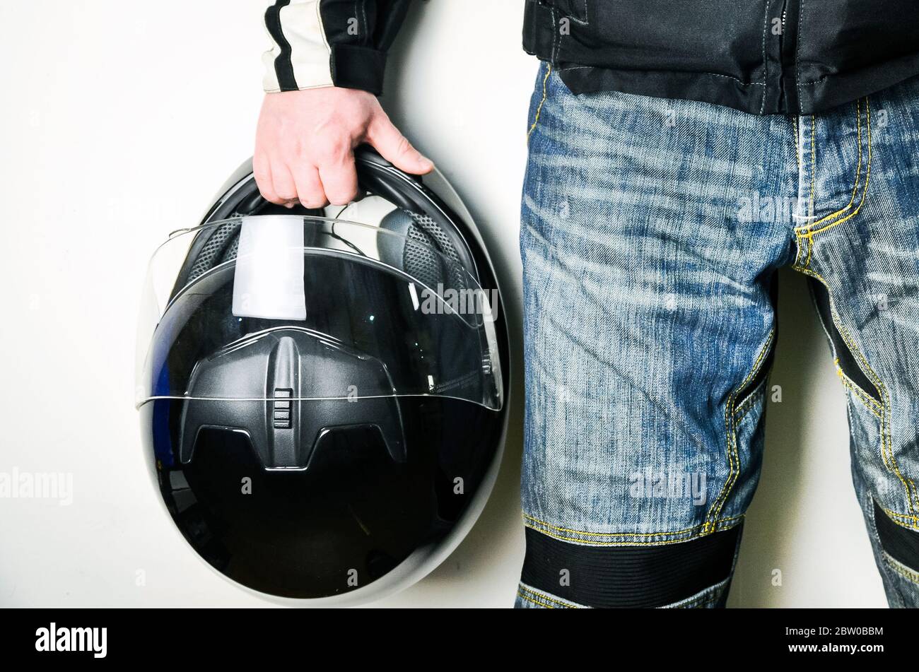 Black motorcycle helmet in biker's hand Stock Photo - Alamy