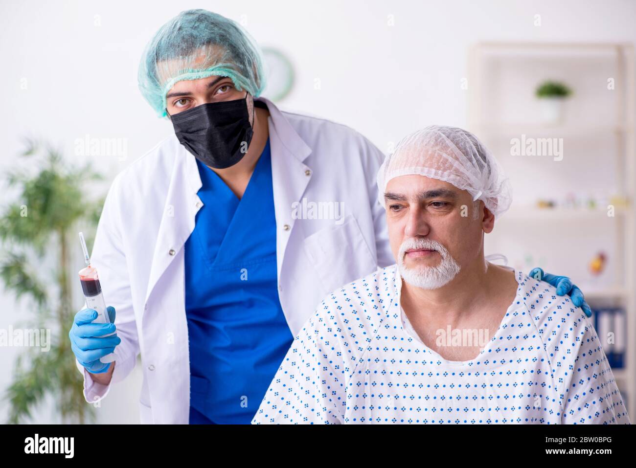 Old man visiting young intern doctor Stock Photo - Alamy