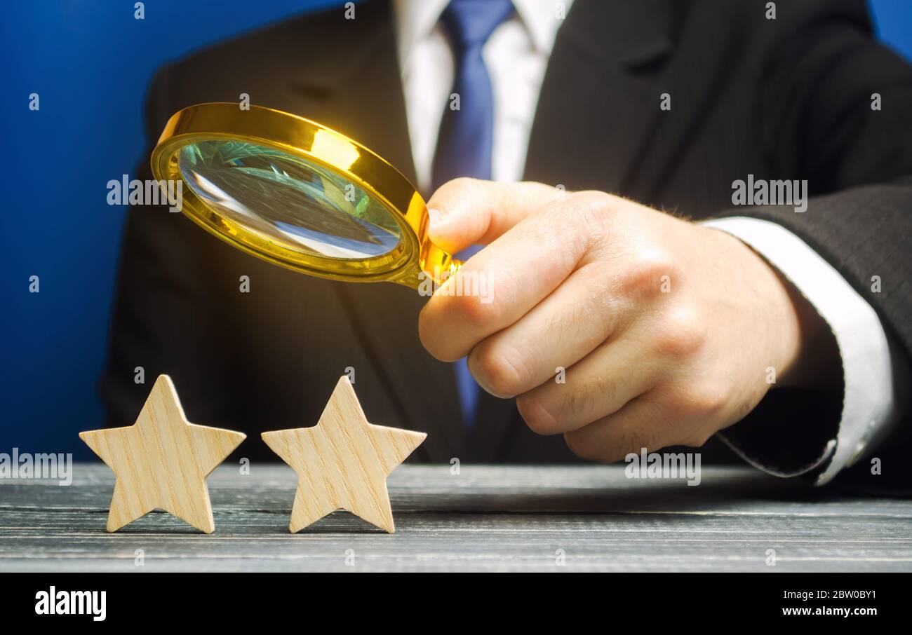 A critic holds a magnifying glass over two stars. Rating, feedback and ...