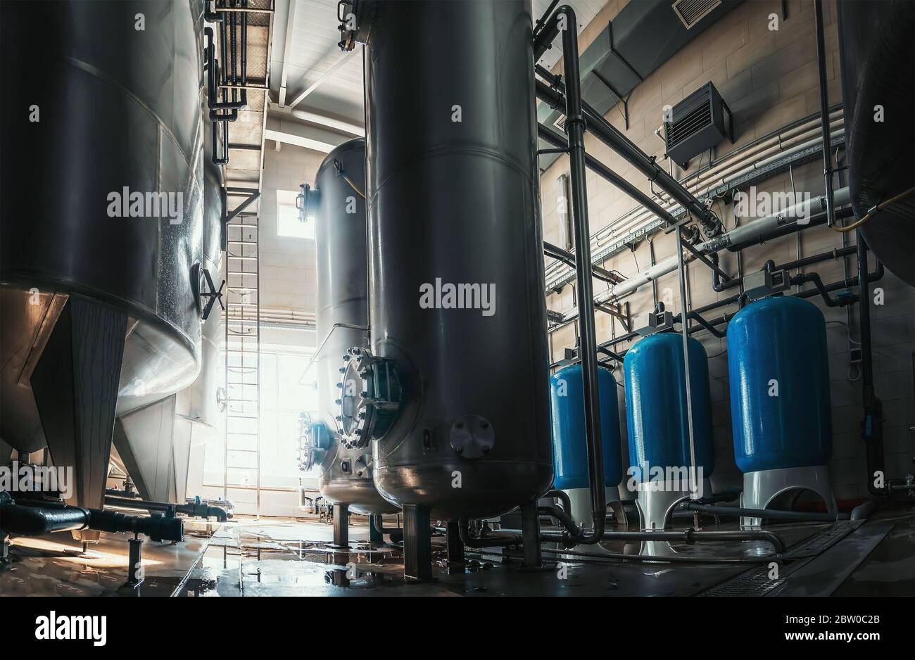 Industrial interior of water factory production. Large steel tanks for ...
