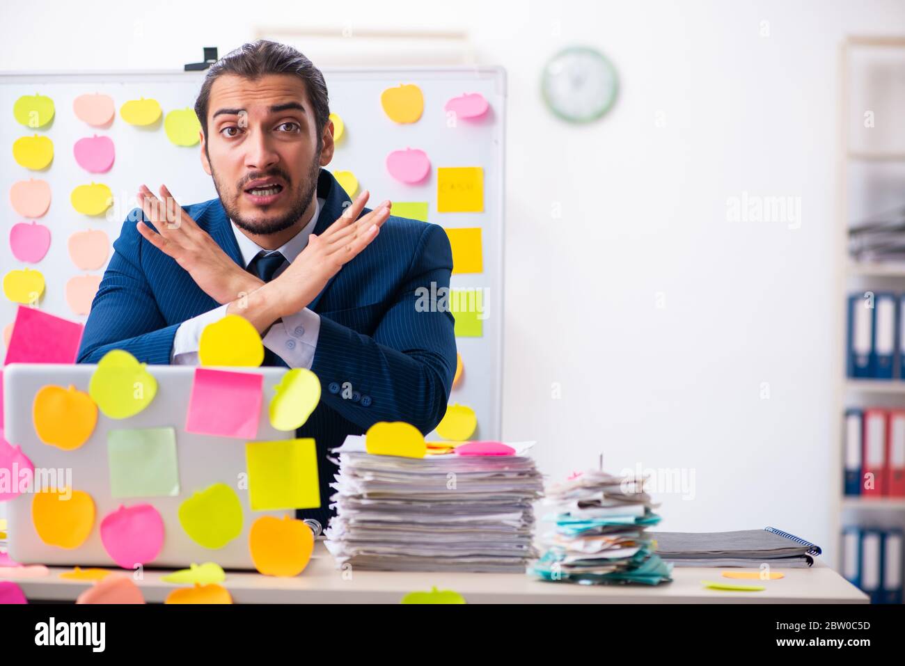 Young employee in conflicting priorities concept Stock Photo - Alamy