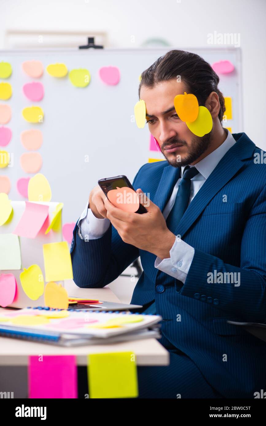 Young employee in conflicting priorities concept Stock Photo - Alamy