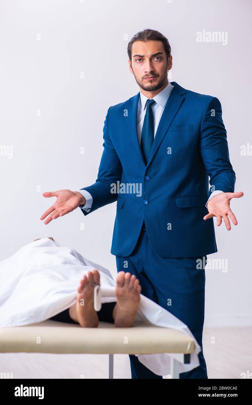 Police coroner examining dead body in morgue Stock Photo - Alamy