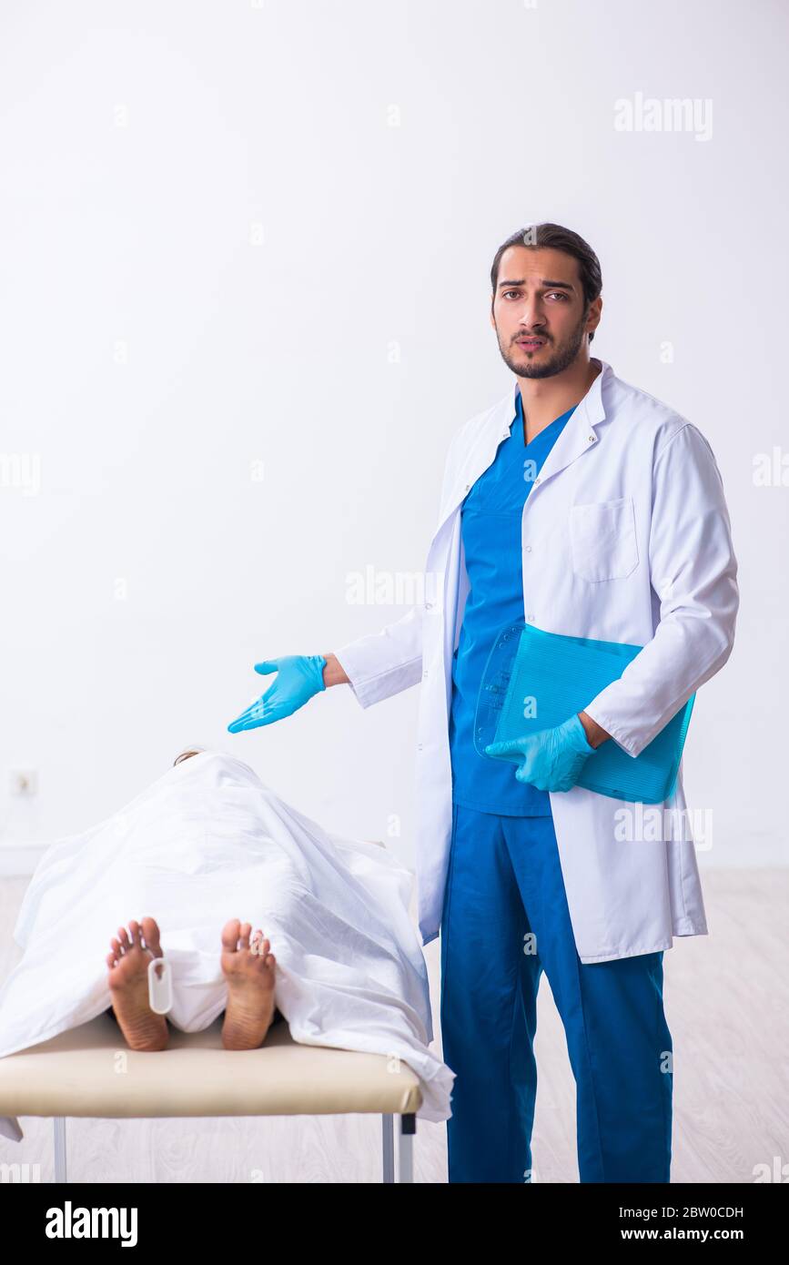 Police coroner examining dead body in morgue Stock Photo - Alamy