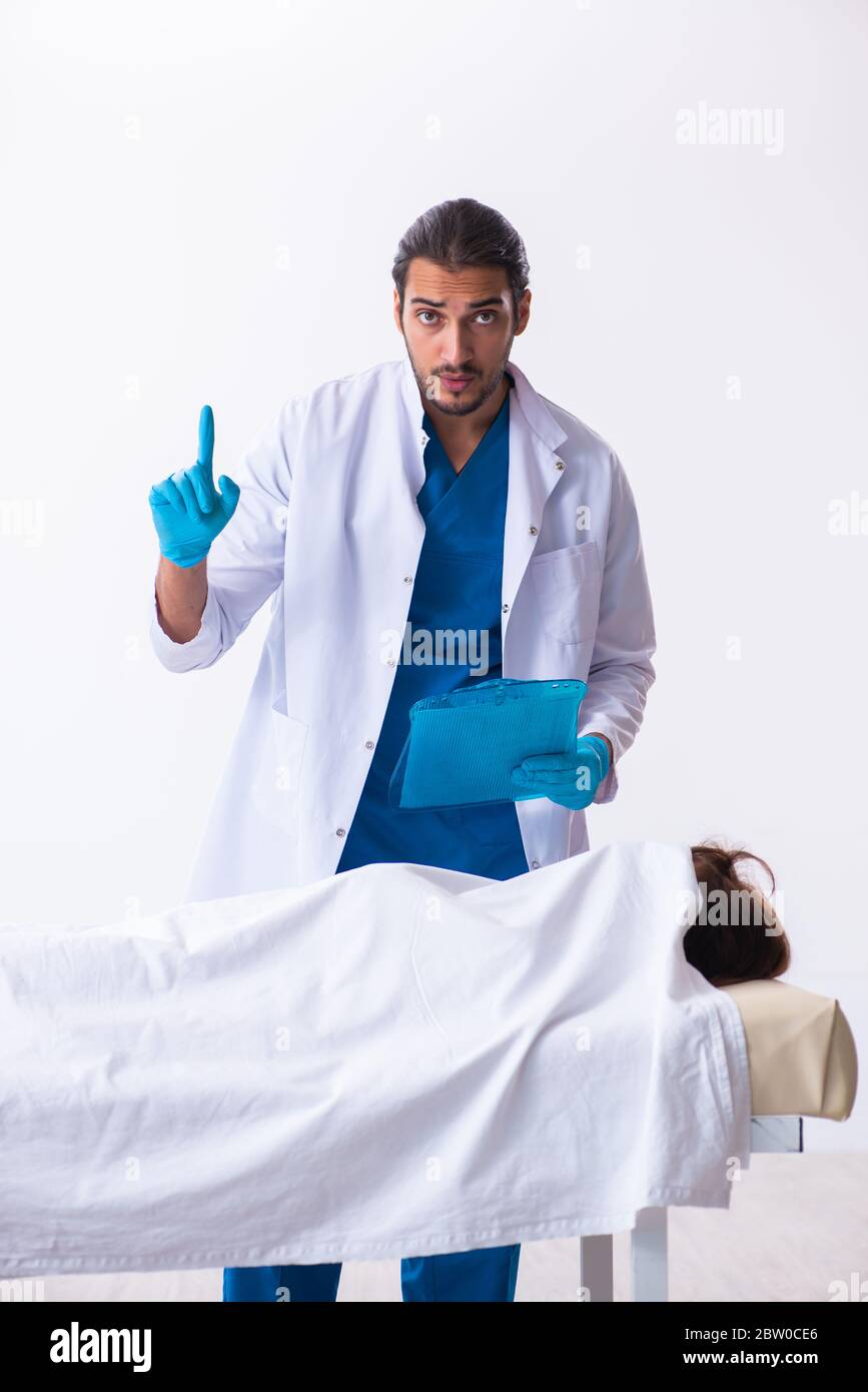 Police coroner examining dead body in morgue Stock Photo - Alamy