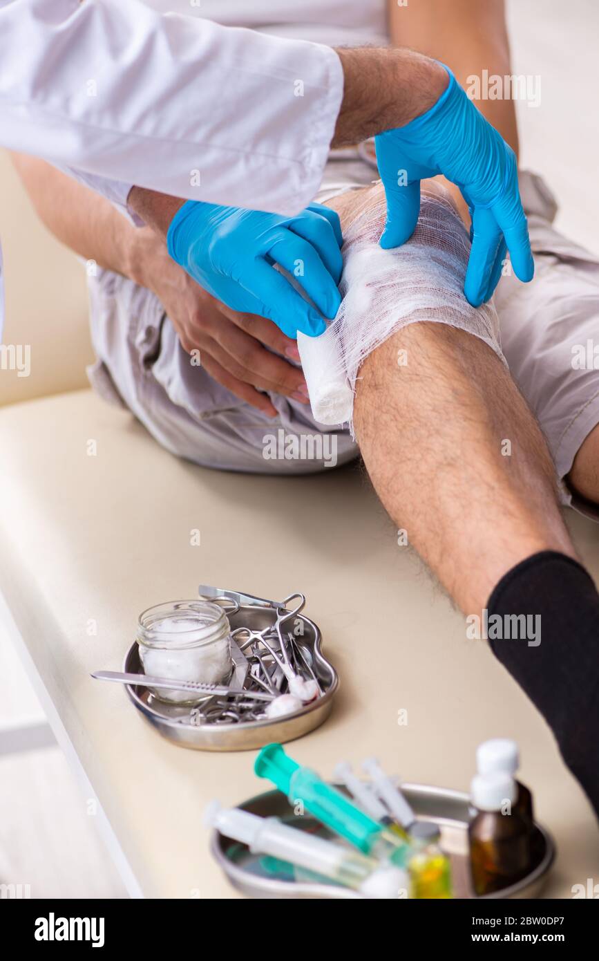 Leg injured man visiting doctor in first aid concept Stock Photo - Alamy