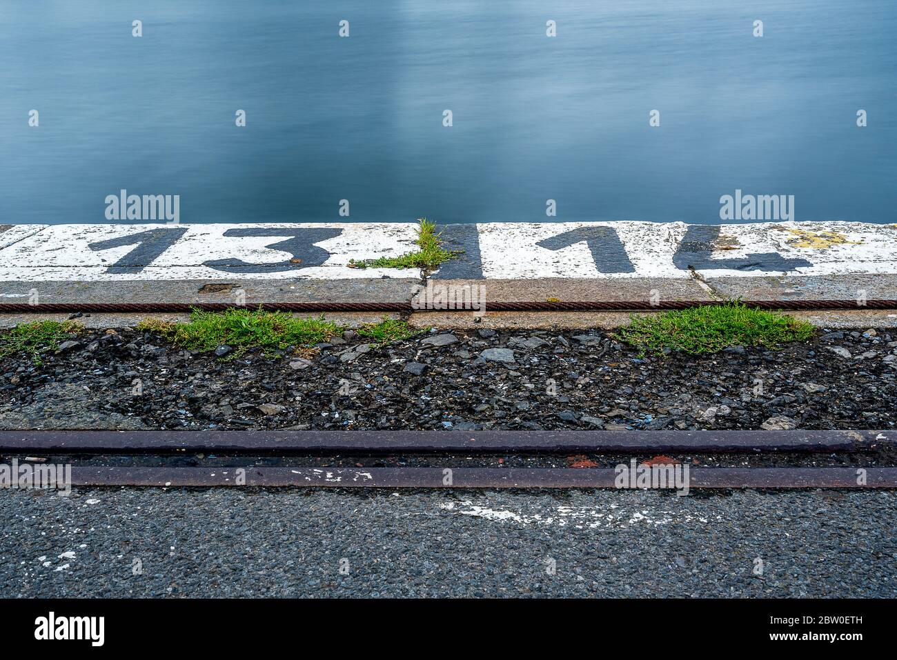 Numbers paint on the ground of a dock with water in background. Rusty ...