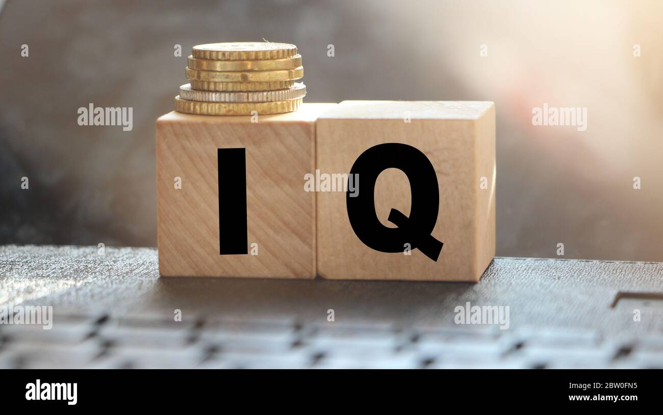 Intelligence quotient. Word IQ on wooden cubes put on laptop keyboard ...
