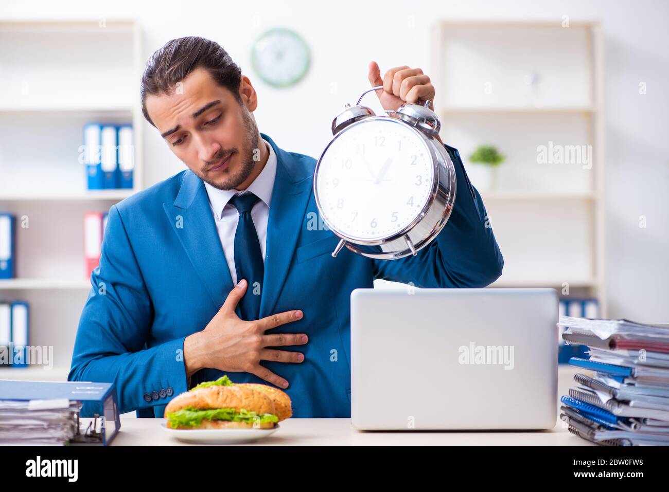 Young employee having breakfast at workplace Stock Photo - Alamy