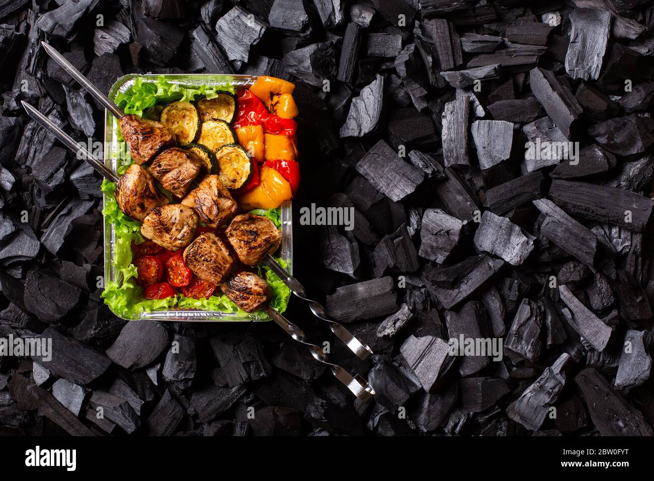 Ready shish kebab. Portion of grilled meat and vegetables in a ...