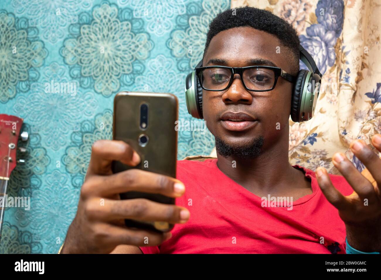 young african man video calling, wearing headphones Stock Photo - Alamy