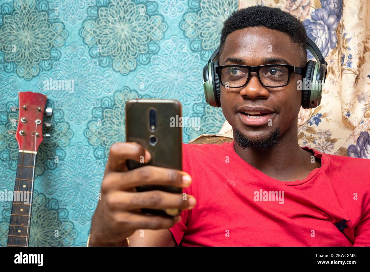 young african man making a video call, wearing headphones Stock Photo ...