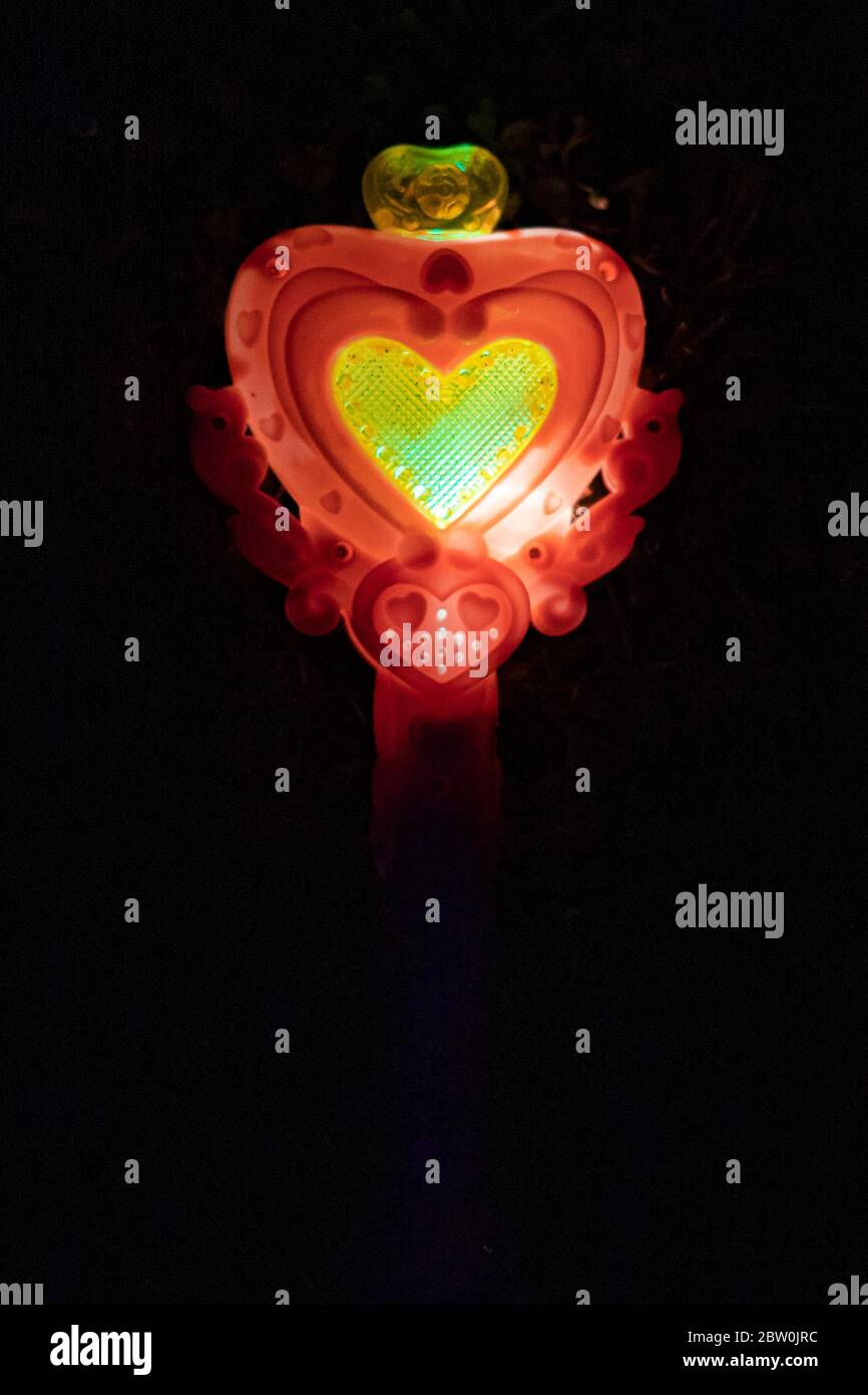 Heart shaped, toy magic wand, pink and yellow, shining bright in the ...