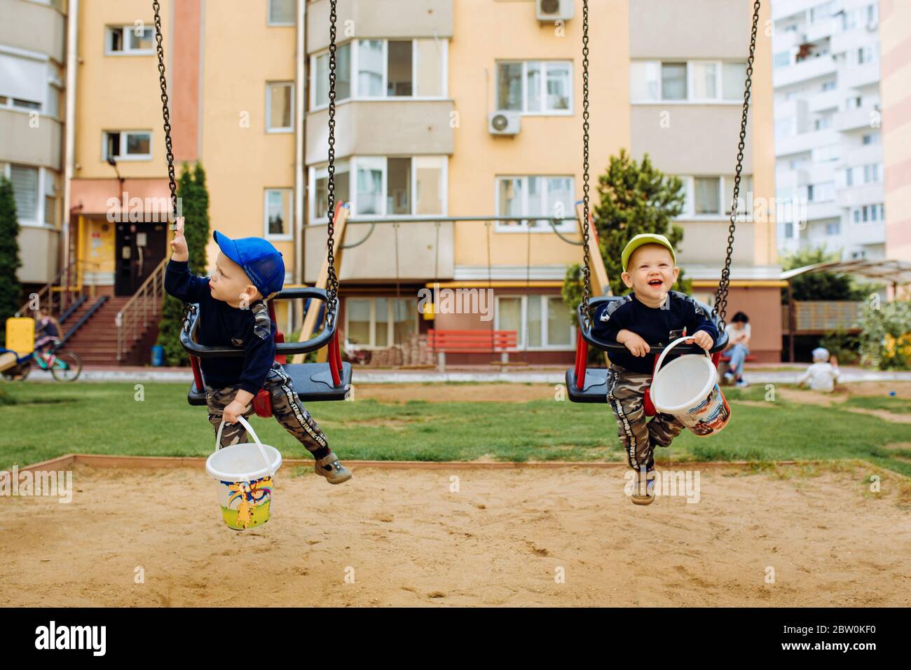 2 twin brothers ride together on a swing, 1-2 years Stock Photo - Alamy
