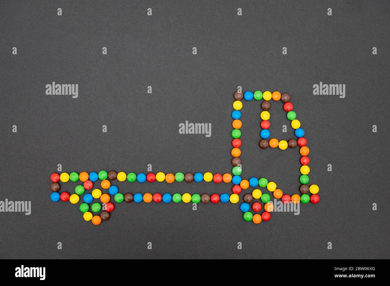 Truck shape made of colorful candies on black background Stock Photo ...