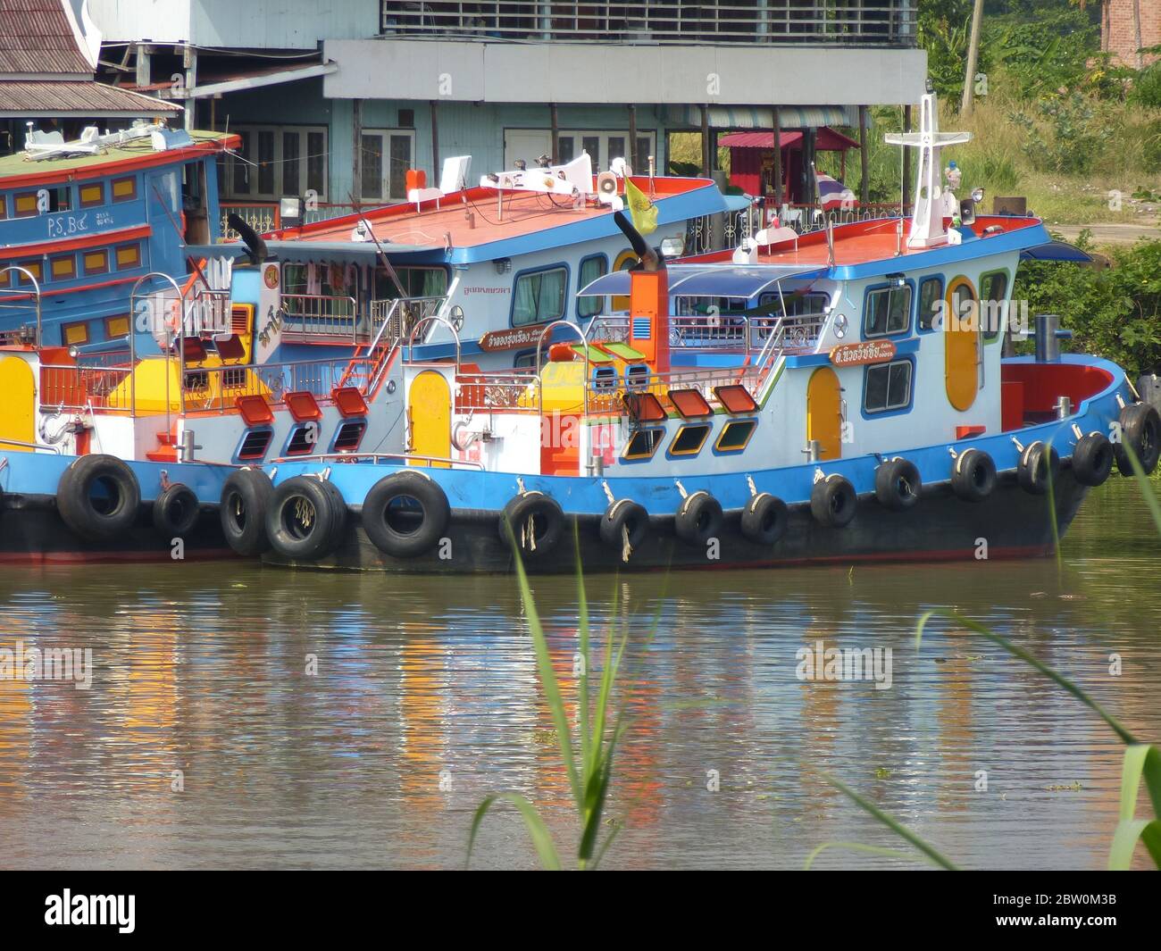 Colorful tug ships in Thailand Stock Photo - Alamy