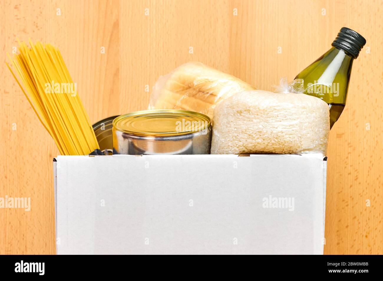 Donation box with canned food, pasta and rice on a wooden background ...
