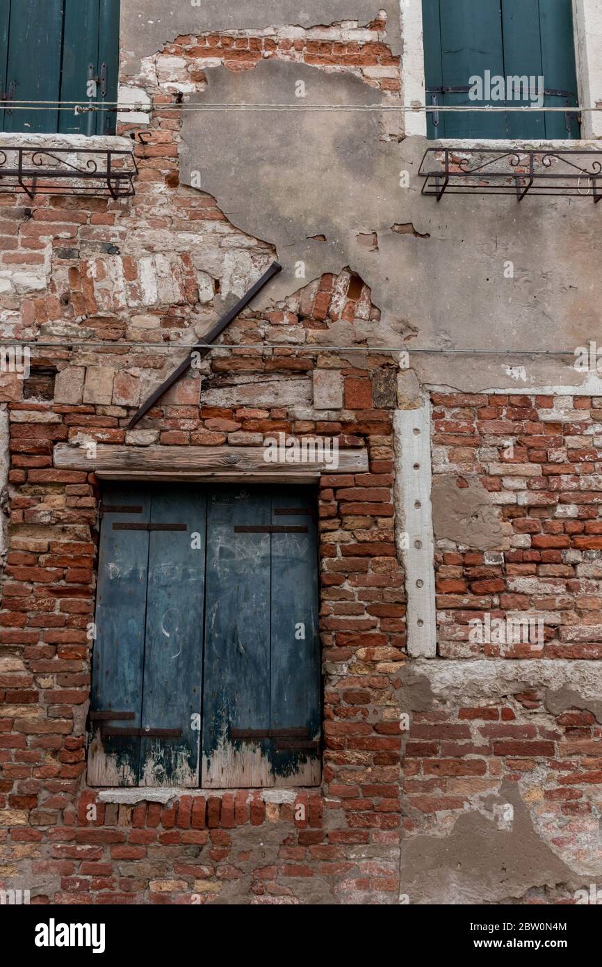 Green window shutter with red bricks with cracks and plaster Stock ...