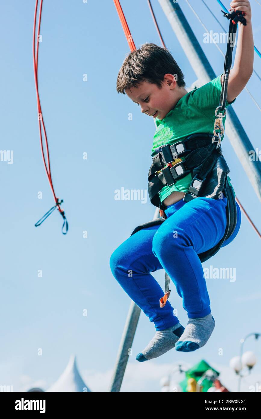 Joyful child playing in the big bungee trampoline at a theme park Stock ...