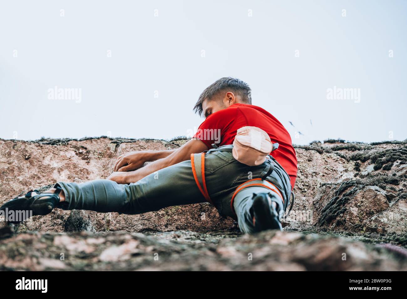 Muscular rock climber practicing rock-climbing on a rock wall Stock ...