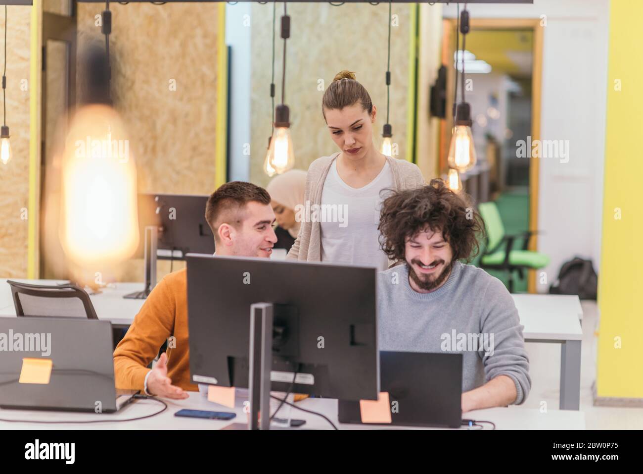 Group of coworkers, colleagues having fun at the office while chatting ...