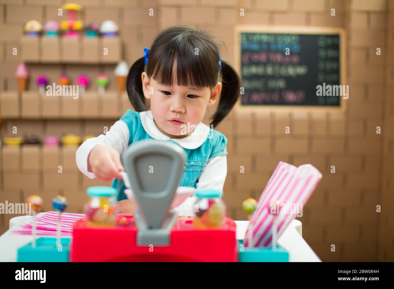 toddler girl pretend play sweet shop keeper at home Stock Photo - Alamy