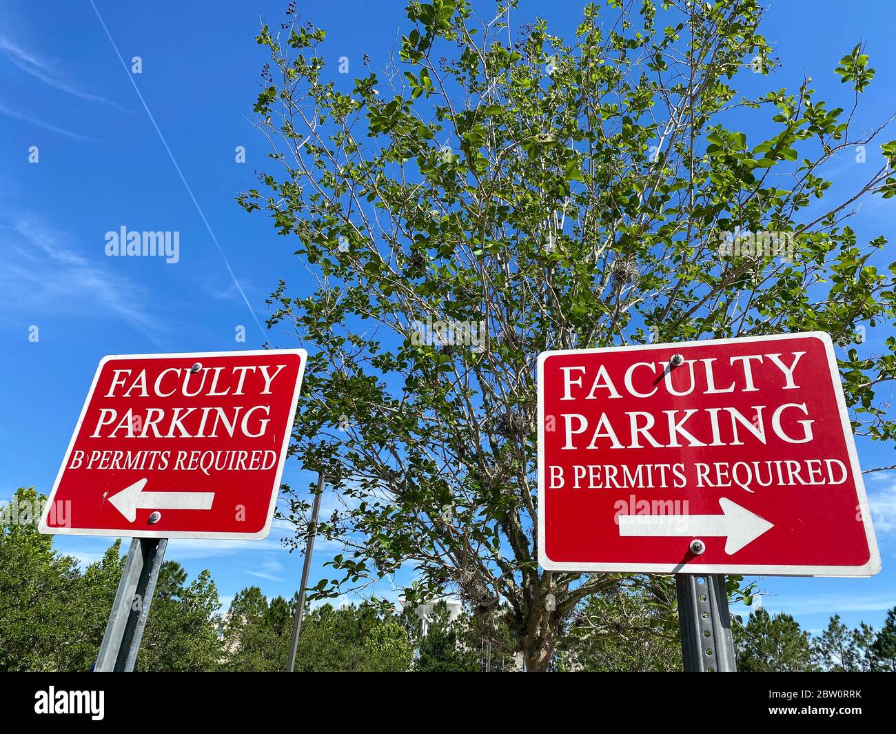 A faculty parking sign in a parking lot of a university office building ...