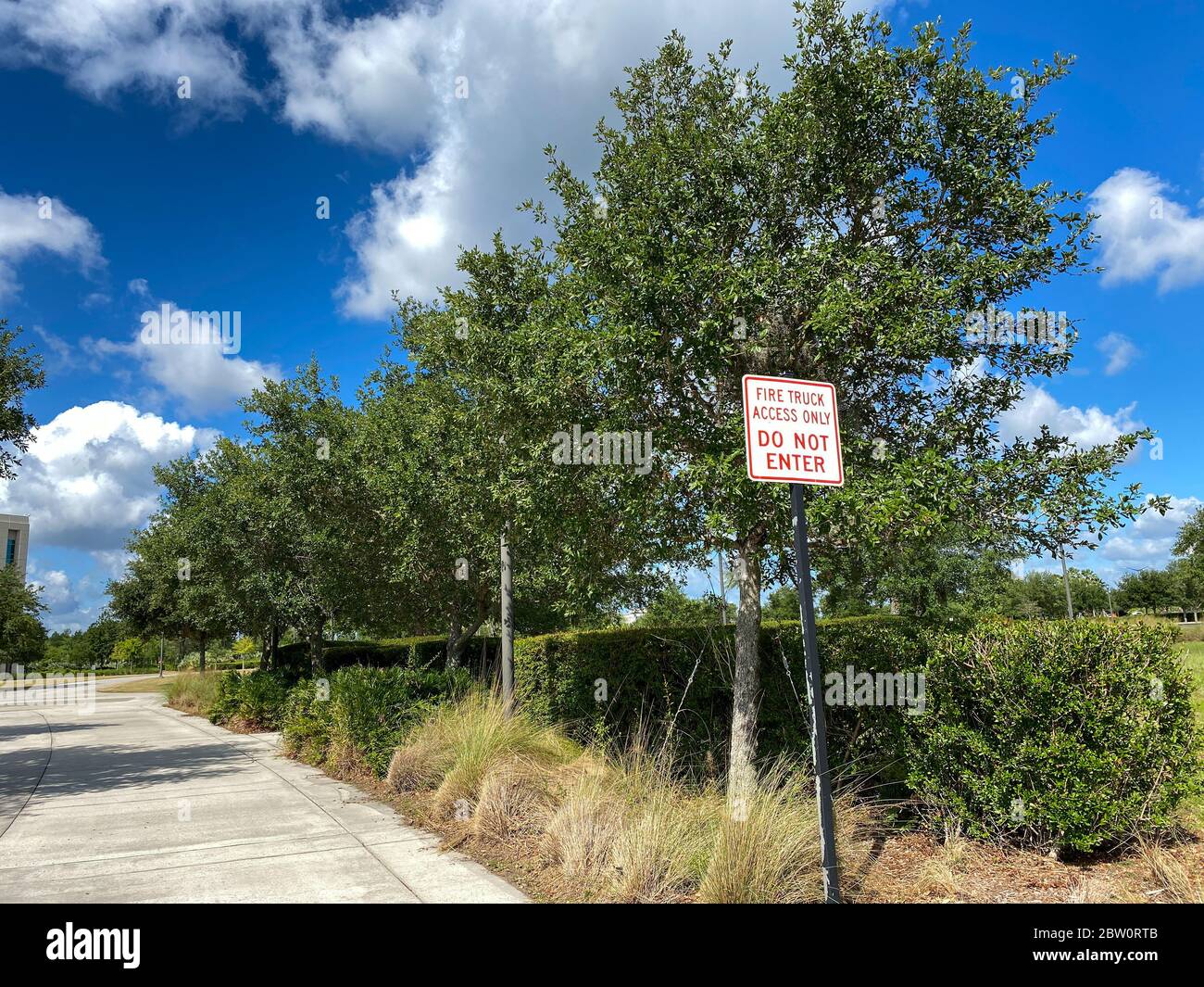 A sign that says Fire Truck Access Only Do Not Enter along a road in an ...
