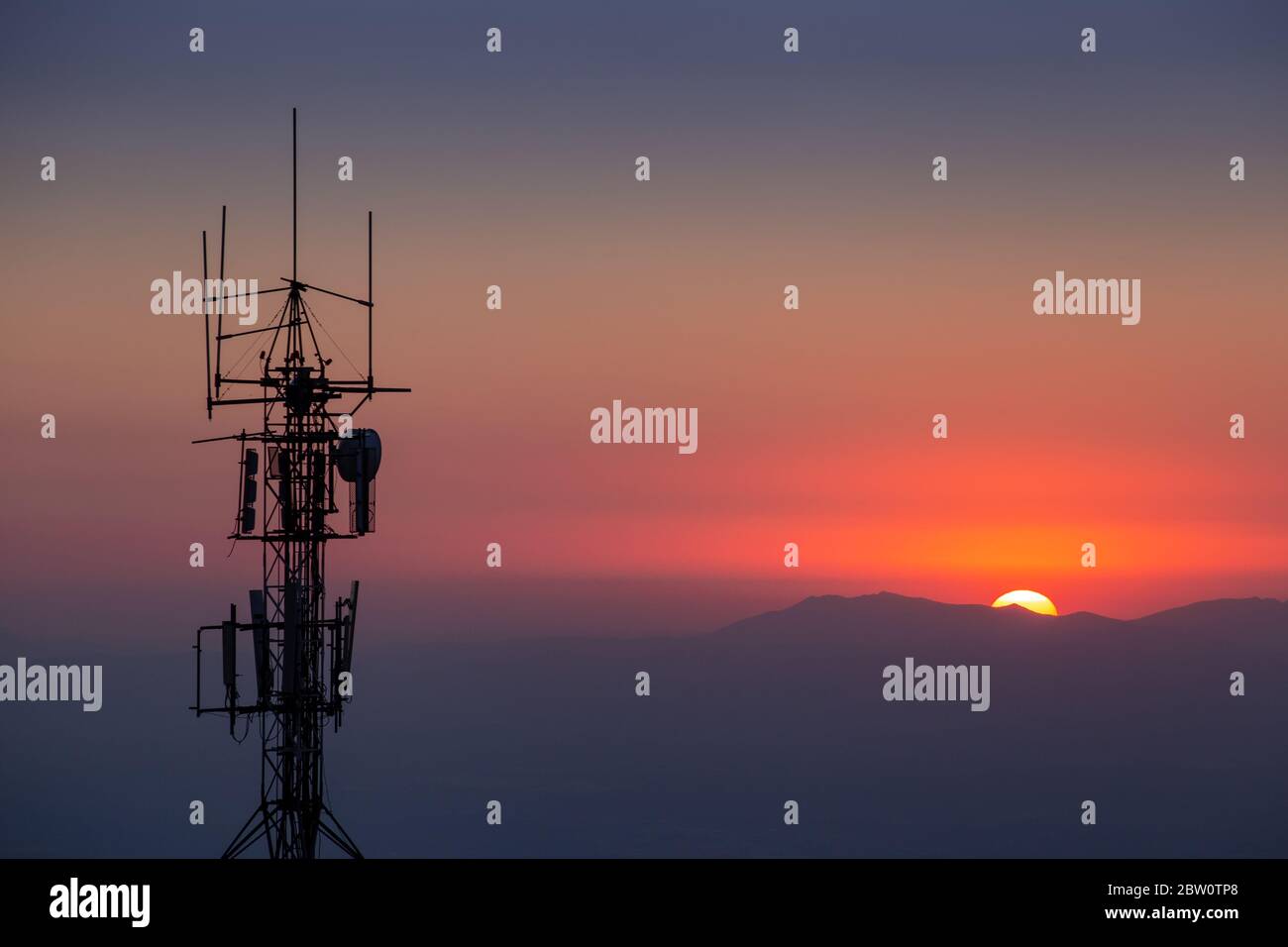 Telecommunication tower with mountains background at sunset Stock Photo ...