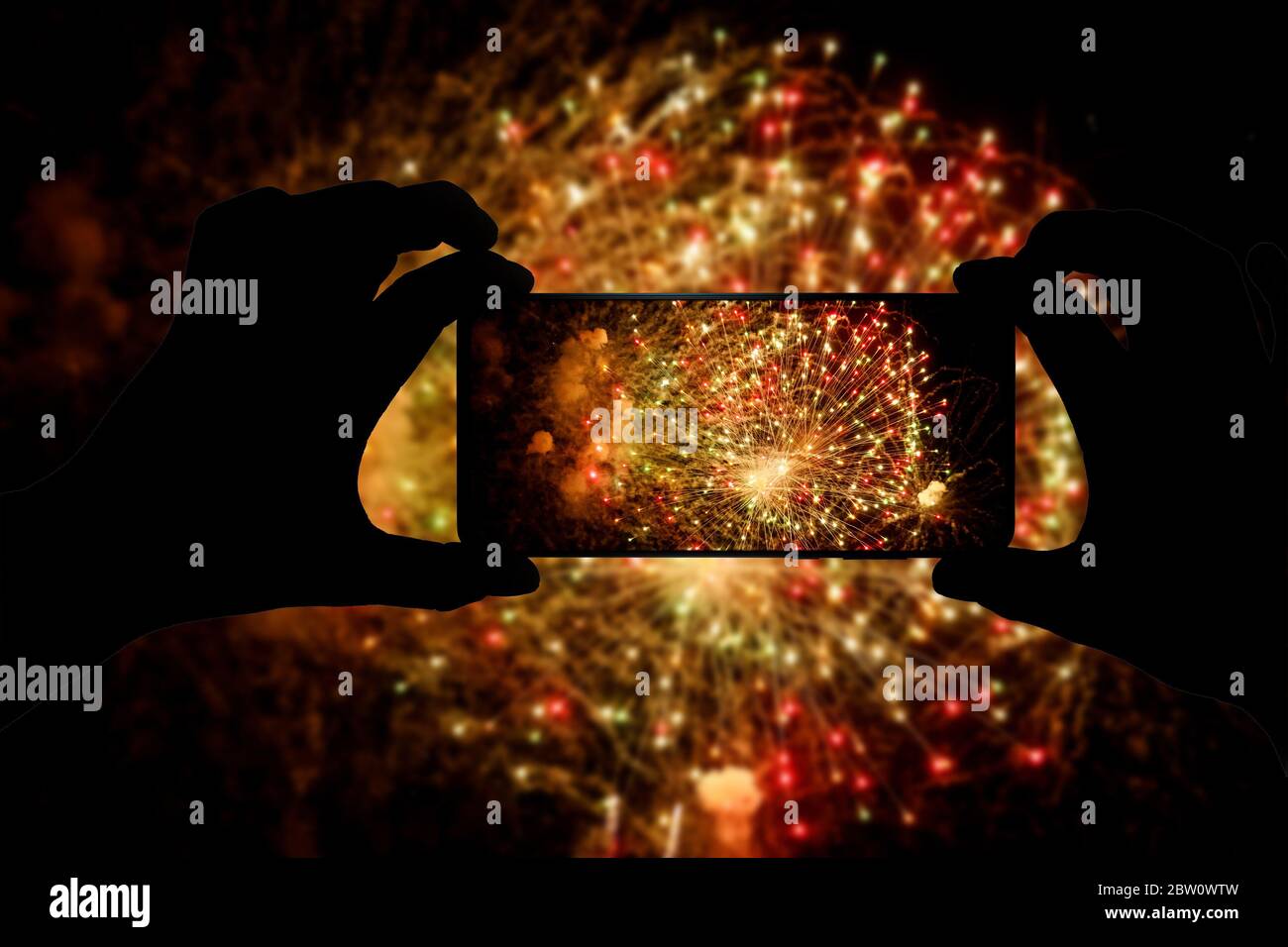 Taking the photo of fireworks via smartphone. Broadcast salute video to ...