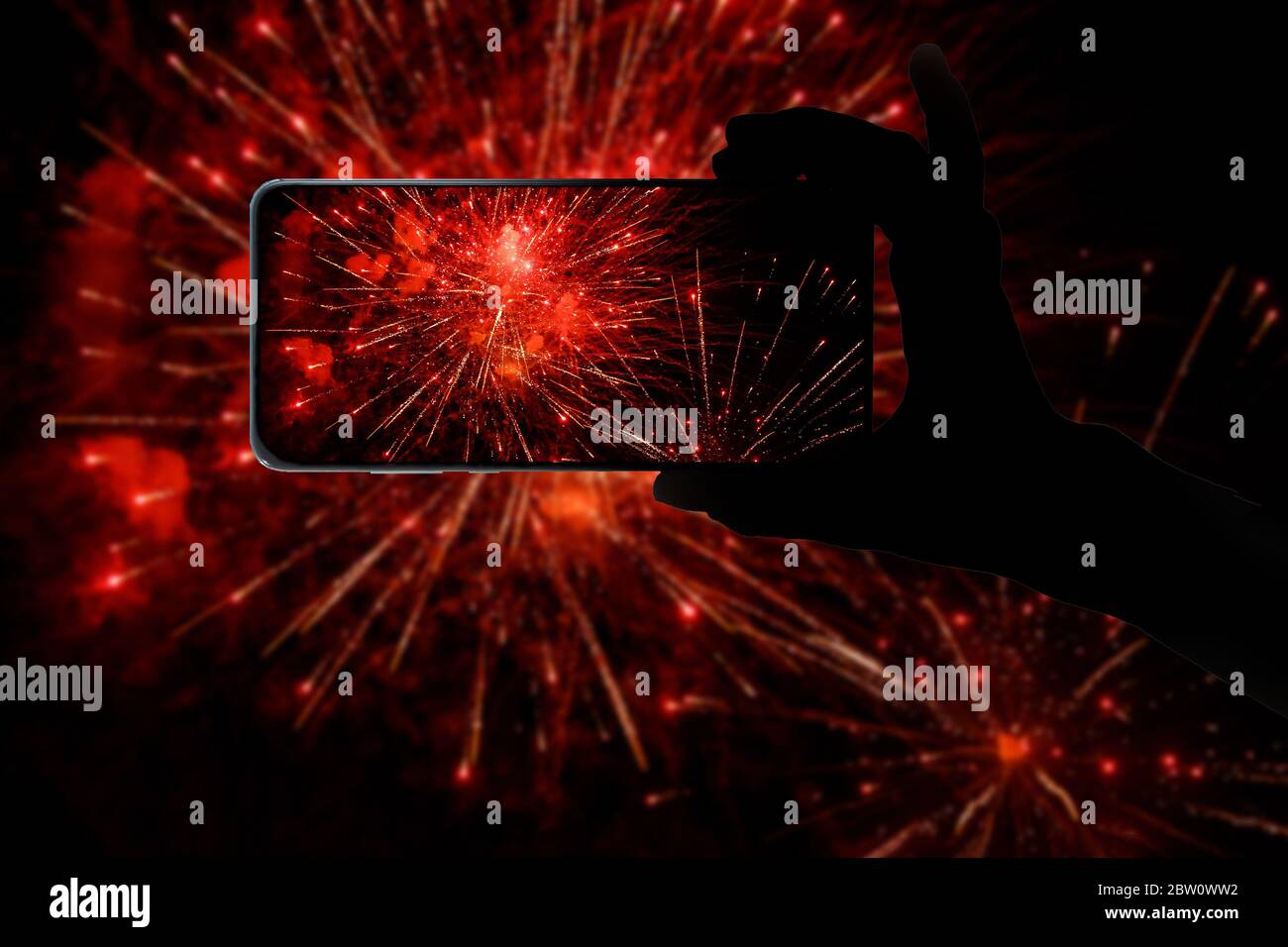 Taking the photo of fireworks via smartphone. Broadcast salute video to ...
