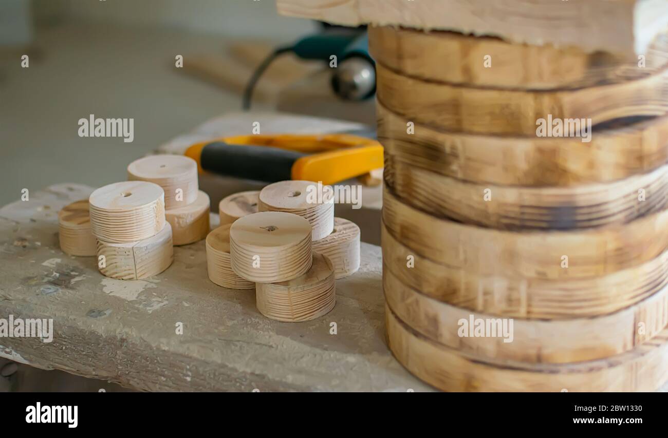 wooden blanks, wheels, circles lie on the carpenter's workbench against ...