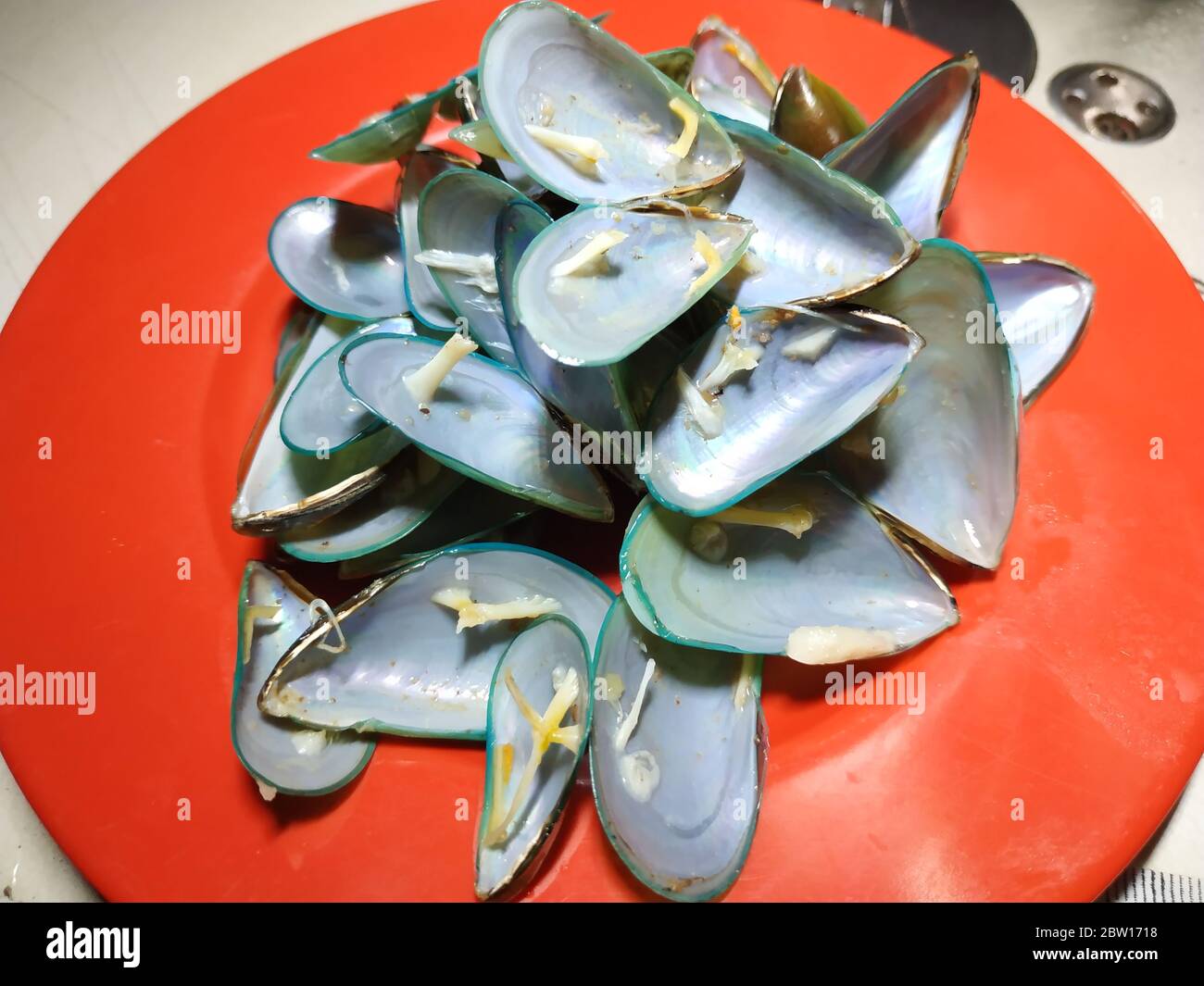 Finished green mussels , empty shell on plate Stock Photo - Alamy