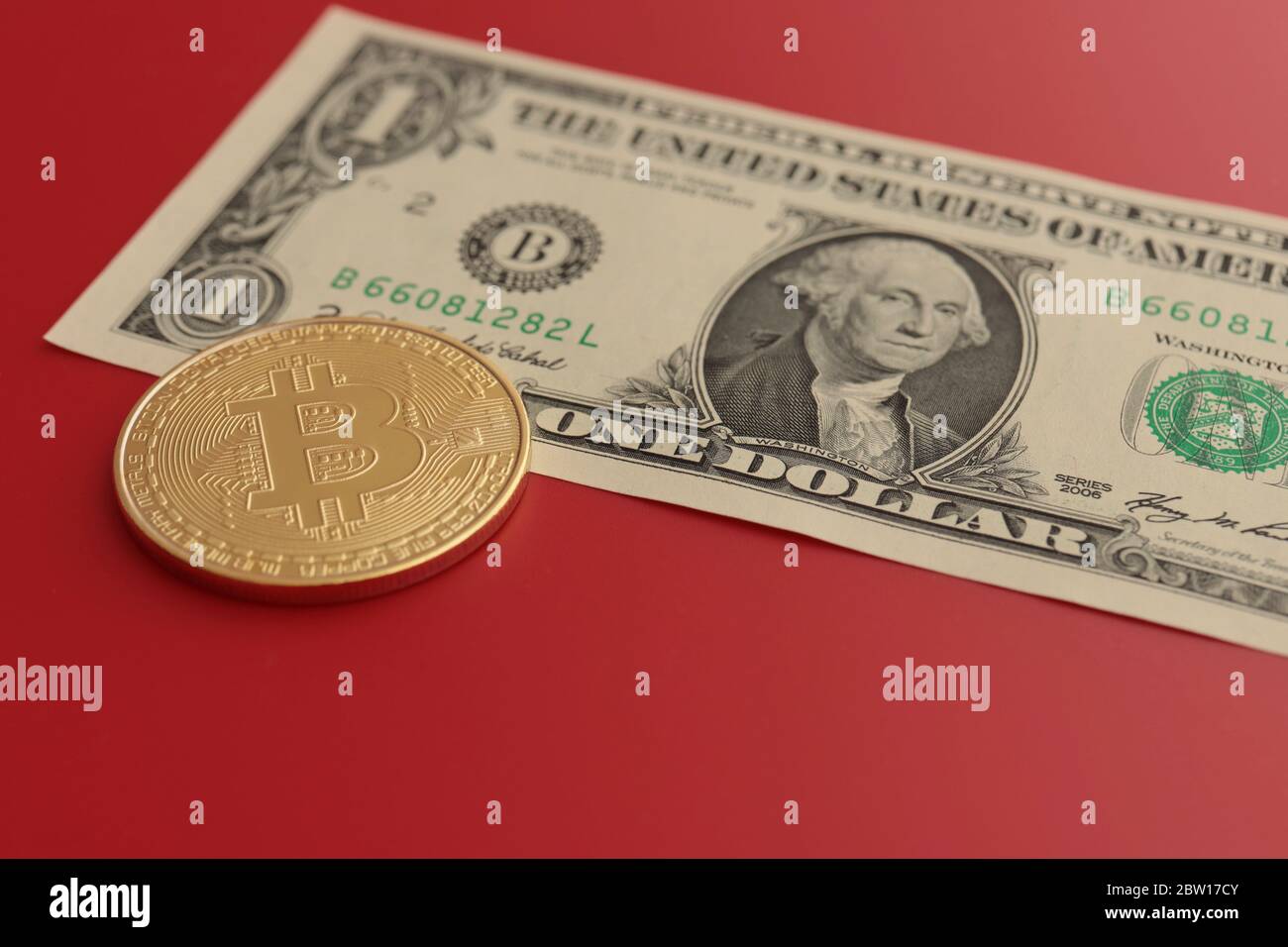 gold metal Bitcoin and dollar bill resting on a red background Stock ...