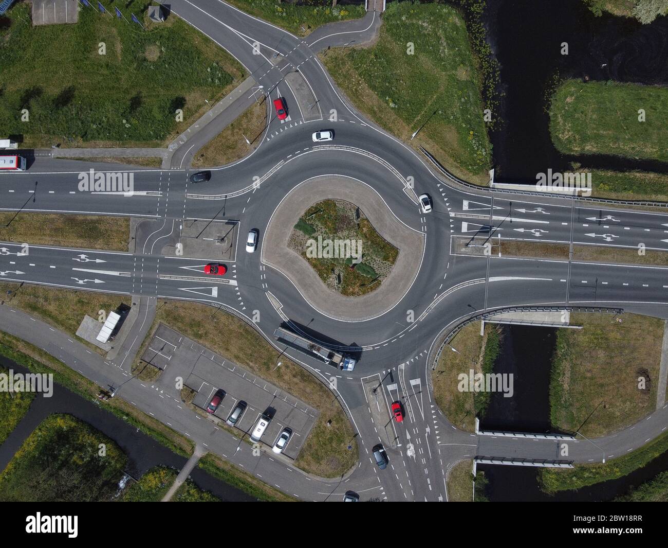 Aerial top down view of a traffic roundabout on a main road in an urban ...