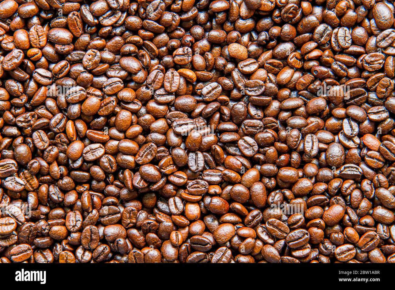 Dark roasted coffee beans background Stock Photo - Alamy