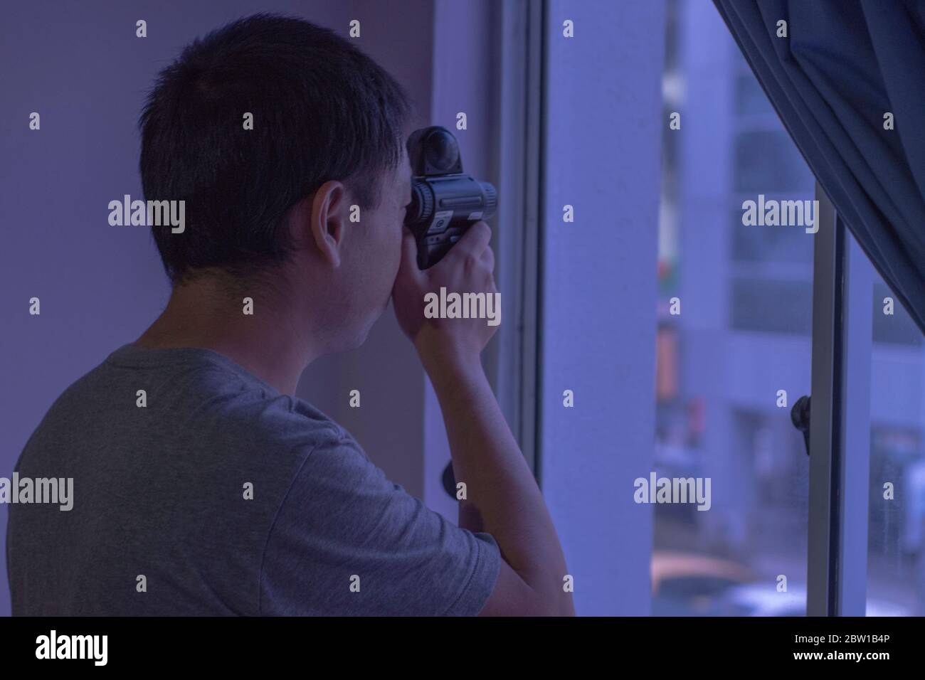 MAN METTERING LIGHT THROUG THE WINDOW WITH PHOTOMETER Stock Photo - Alamy