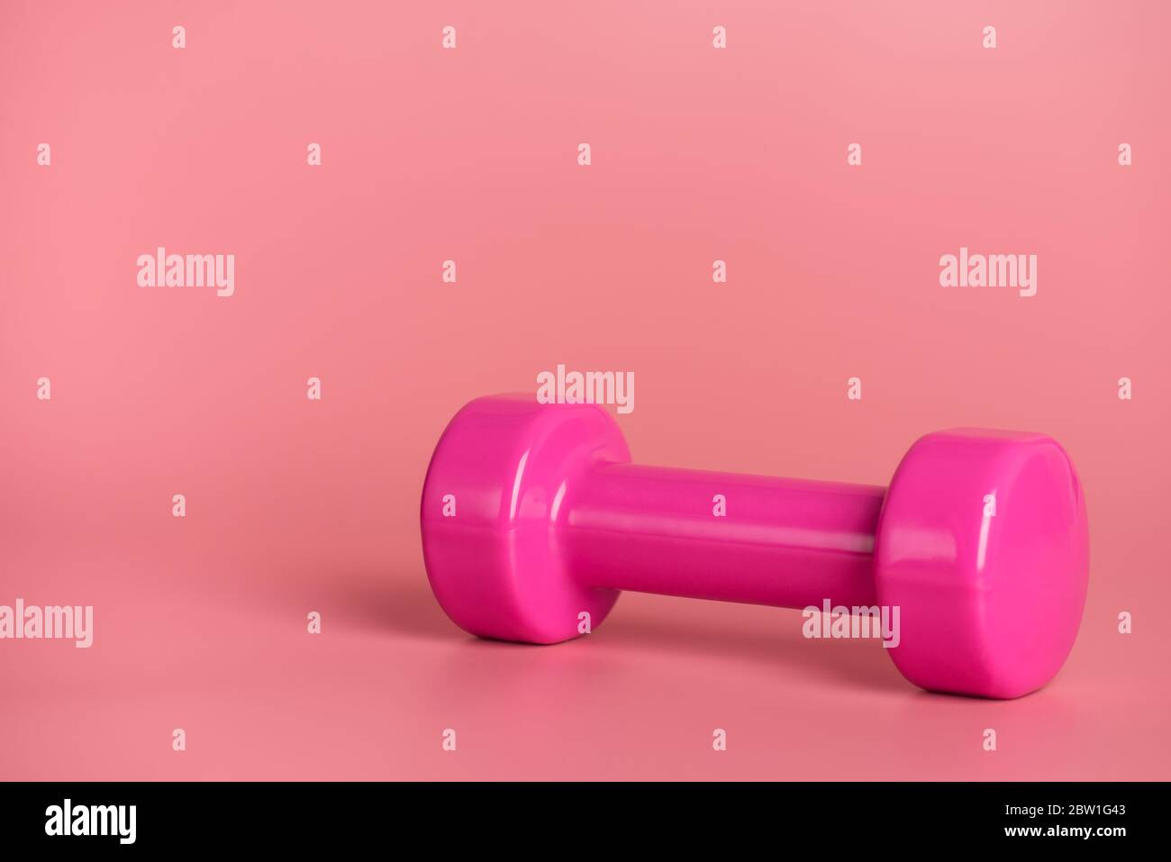 Workout concept. Close-up photo of pink dumbbell isolated on pastel ...