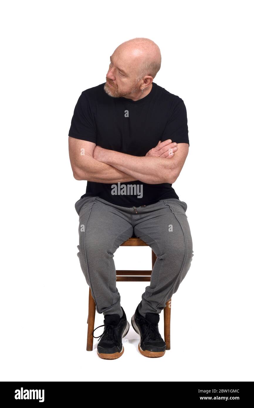 man sitting on chair with arms crossed looking to the side Stock Photo ...