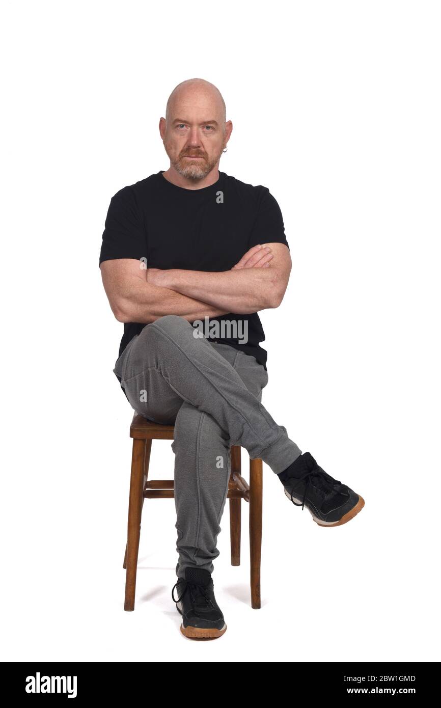 serious bald man with sportswear sitting on white background Stock ...