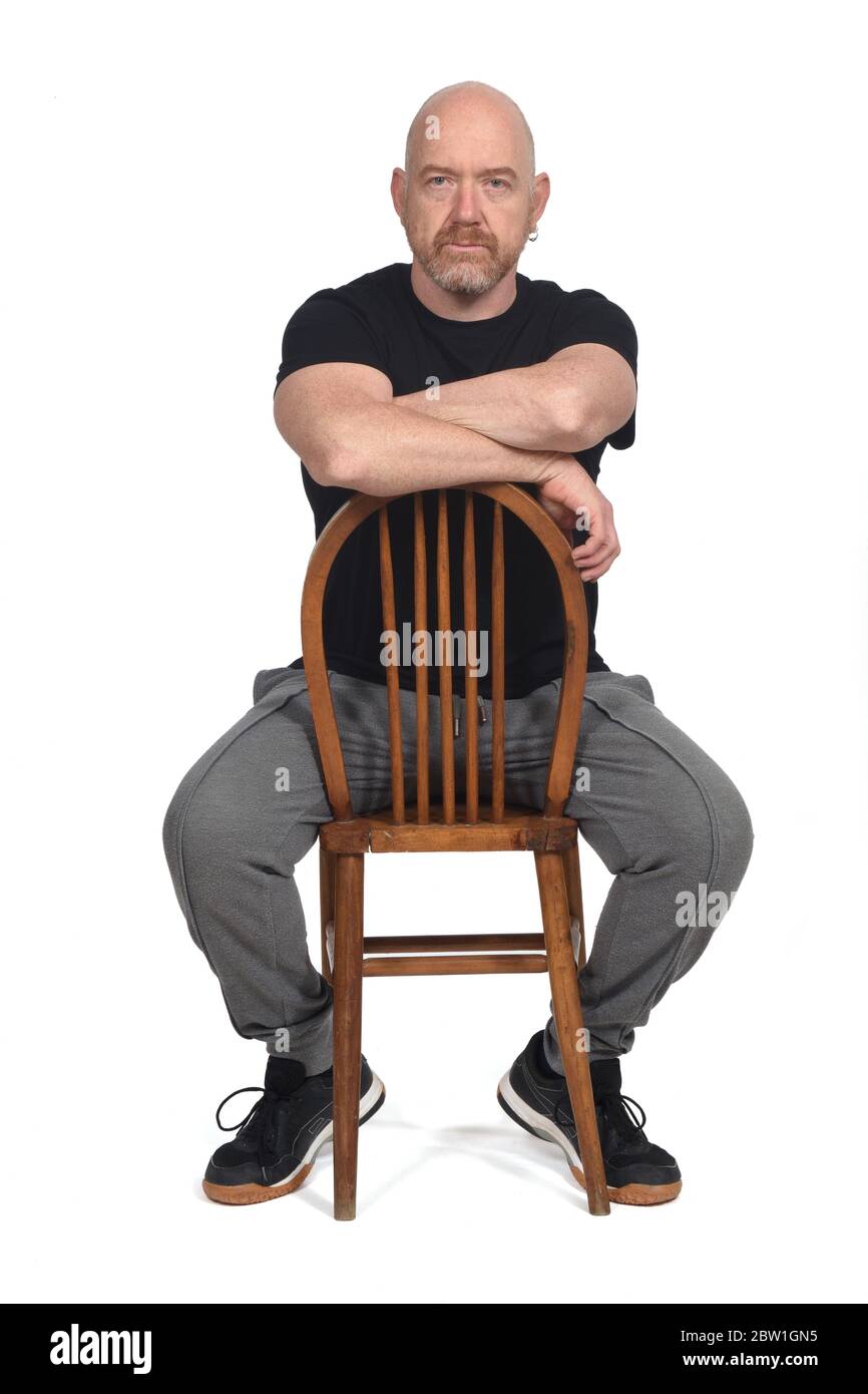 serious bald man with sportswear sitting on white background Stock ...