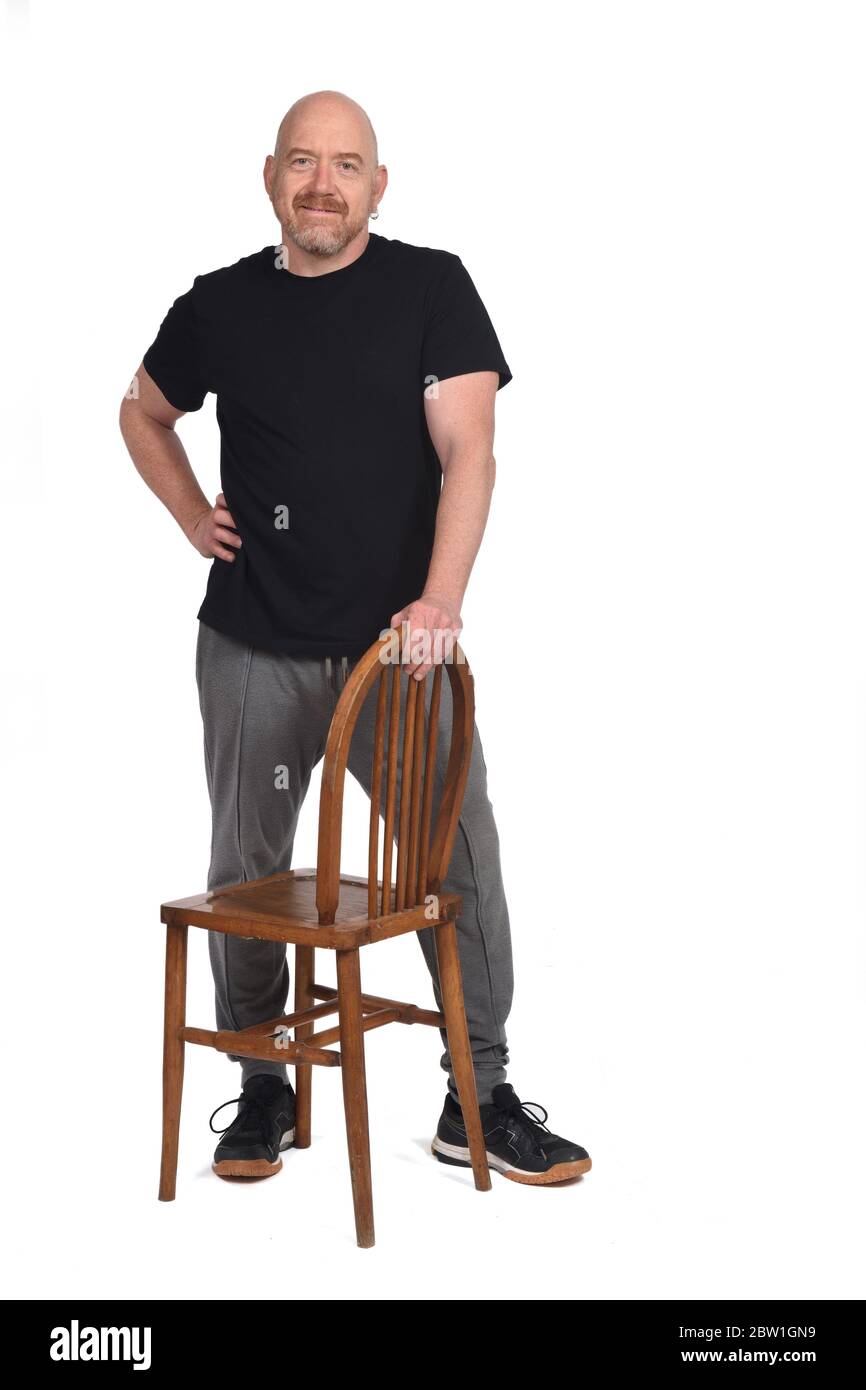 man standing with a chair in white background Stock Photo - Alamy